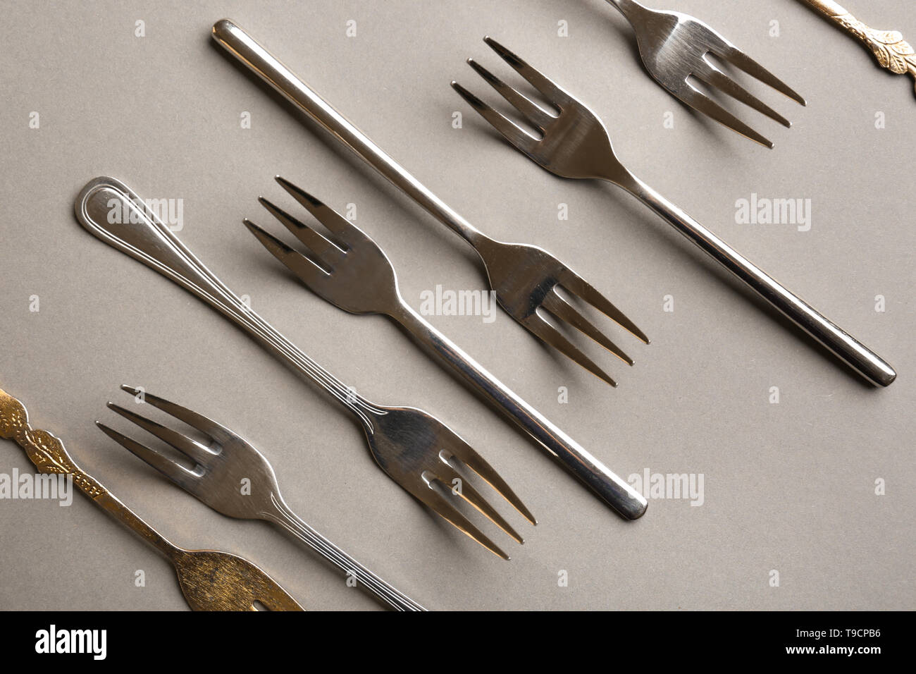 Set of forks on grey background Stock Photo - Alamy