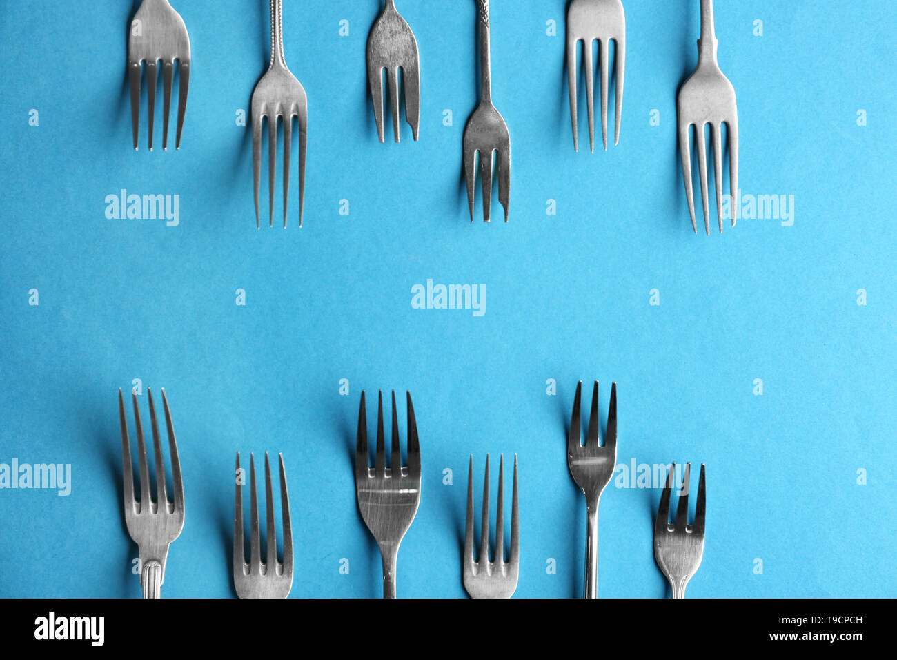 Set of silver forks on colour background Stock Photo - Alamy
