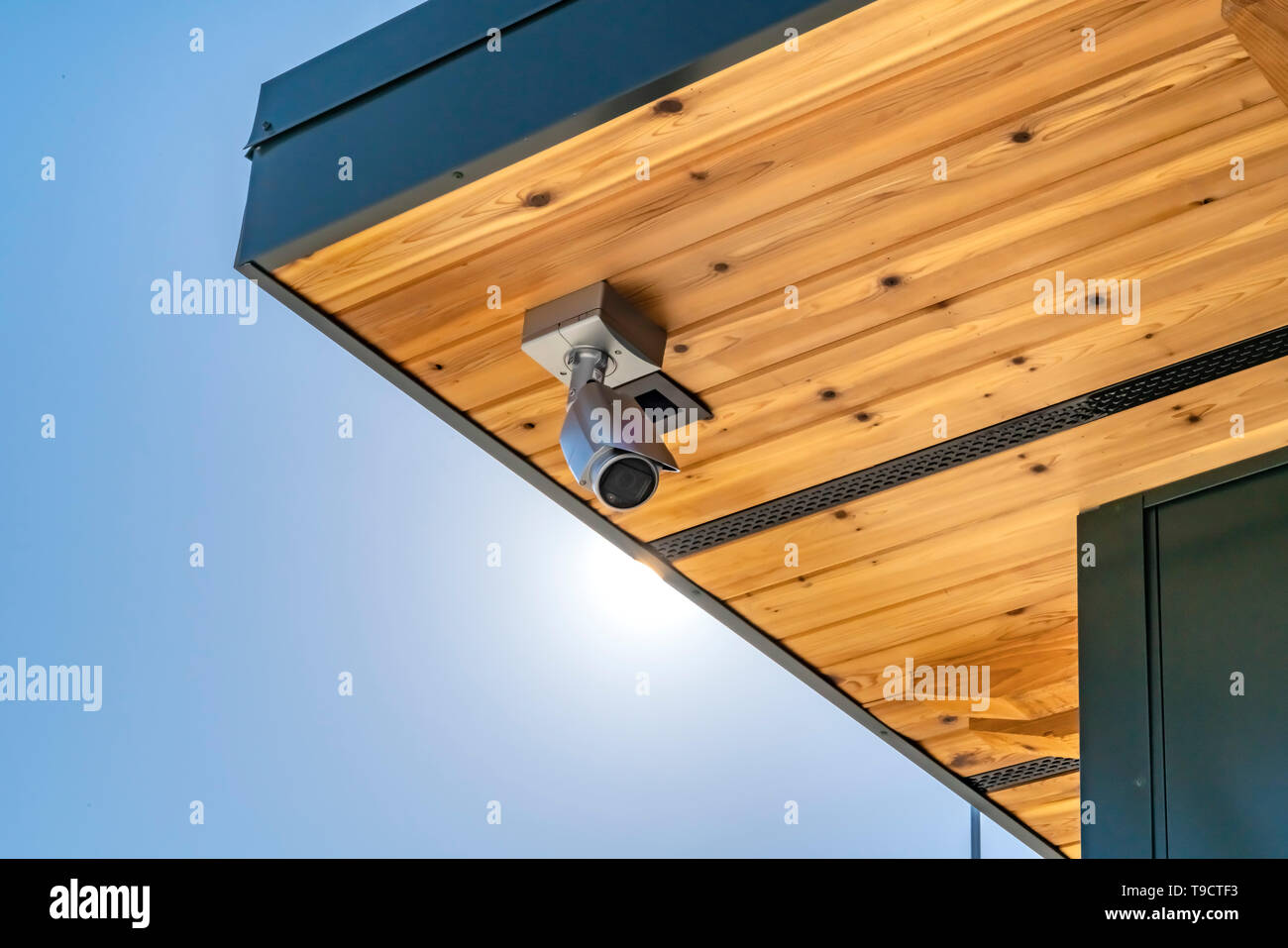 Home with security camera installed on the wooden underside of its roof ...