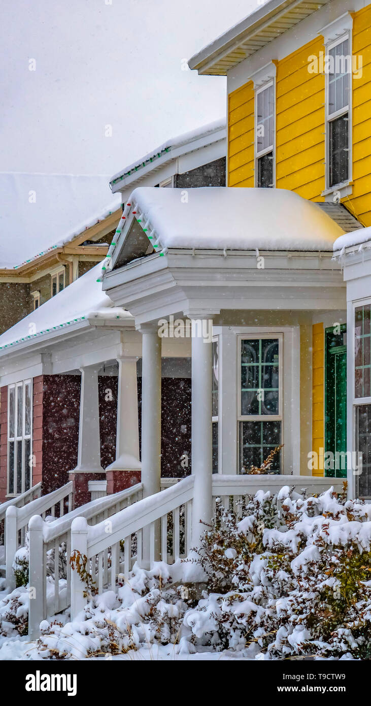 Clear Vertical Lovely houses with snowy roofs and icy yards against ...