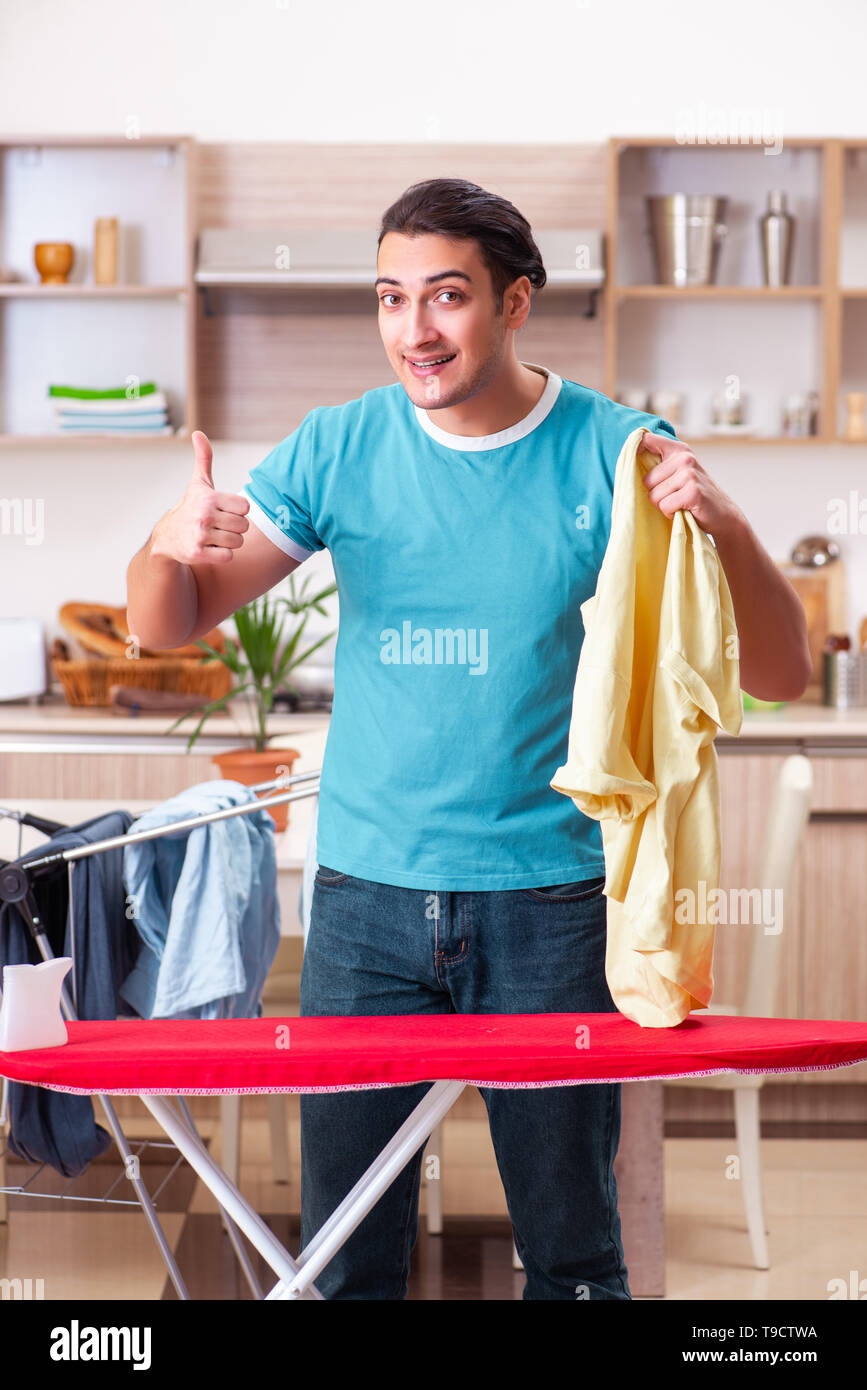 Young man husband doing clothing ironing at home Stock Photo - Alamy