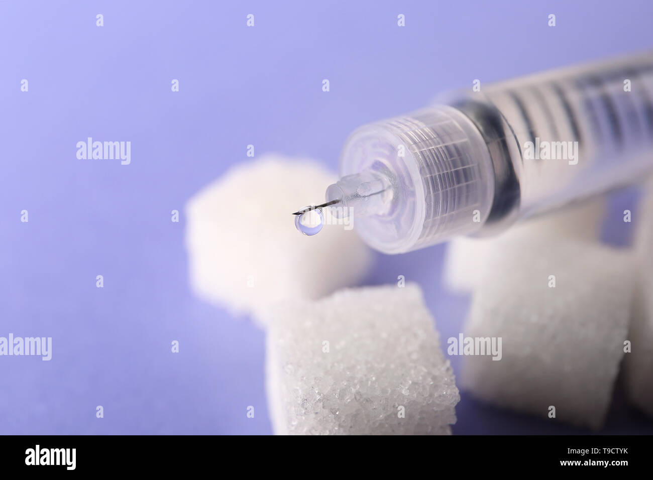 Insulin syringe and sugar cubes on color background, closeup. Diabetes ...