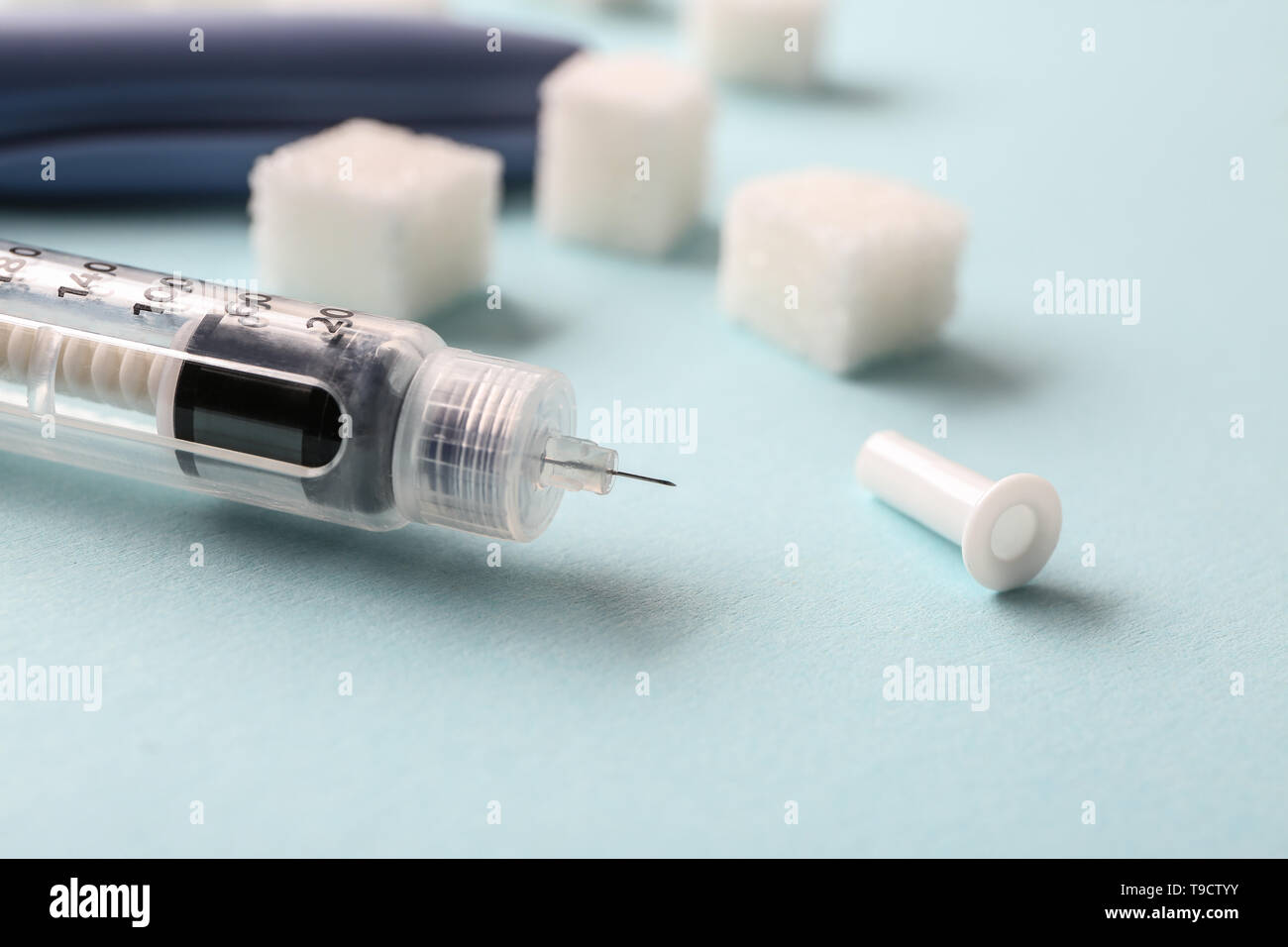 Insulin syringe and sugar cubes on color background, closeup. Diabetes ...