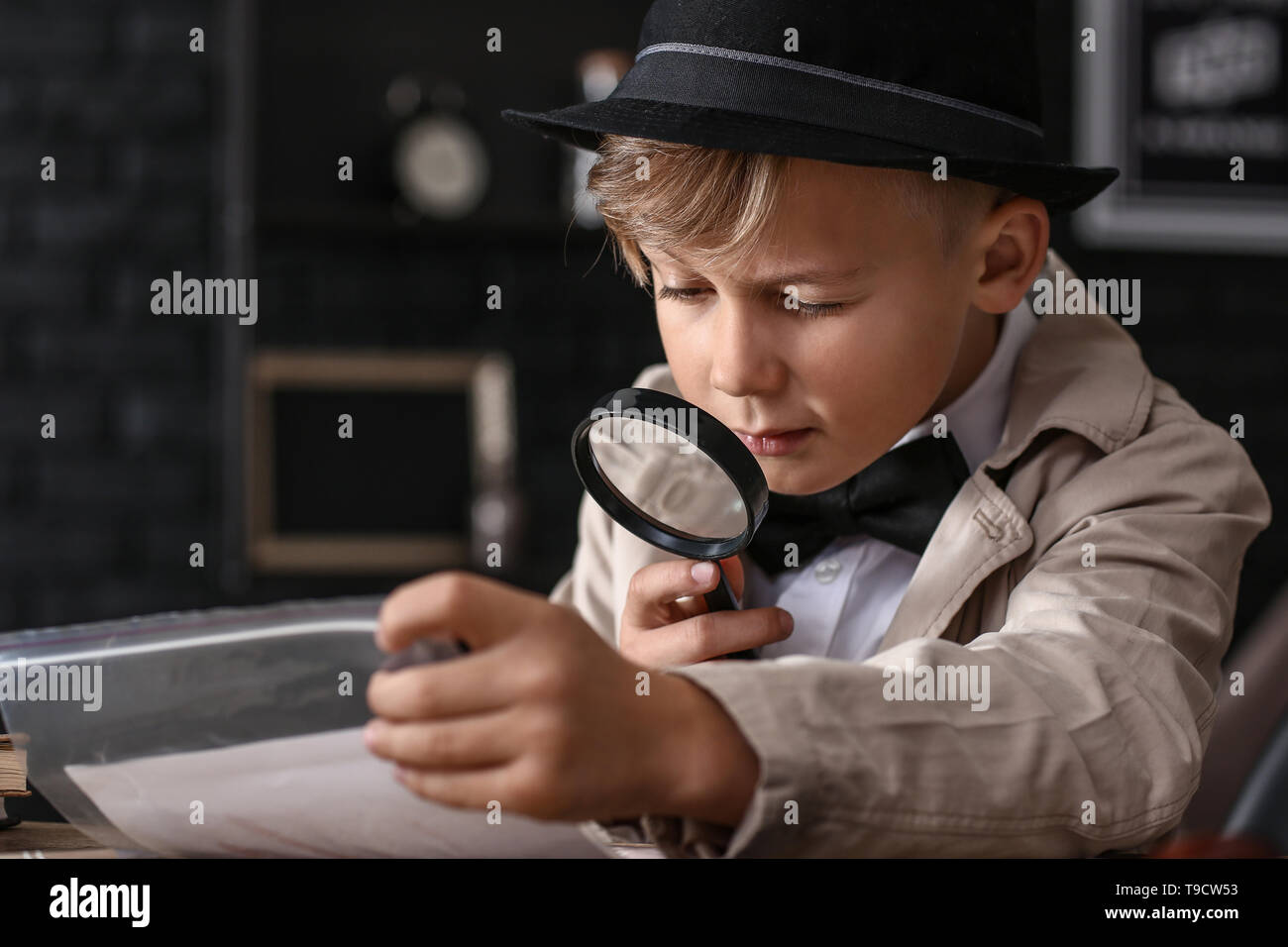 Cute little detective working with evidence at table Stock Photo - Alamy