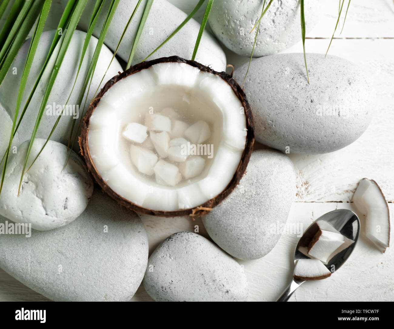 Half of ripe coconut and pebbles on white background Stock Photo - Alamy
