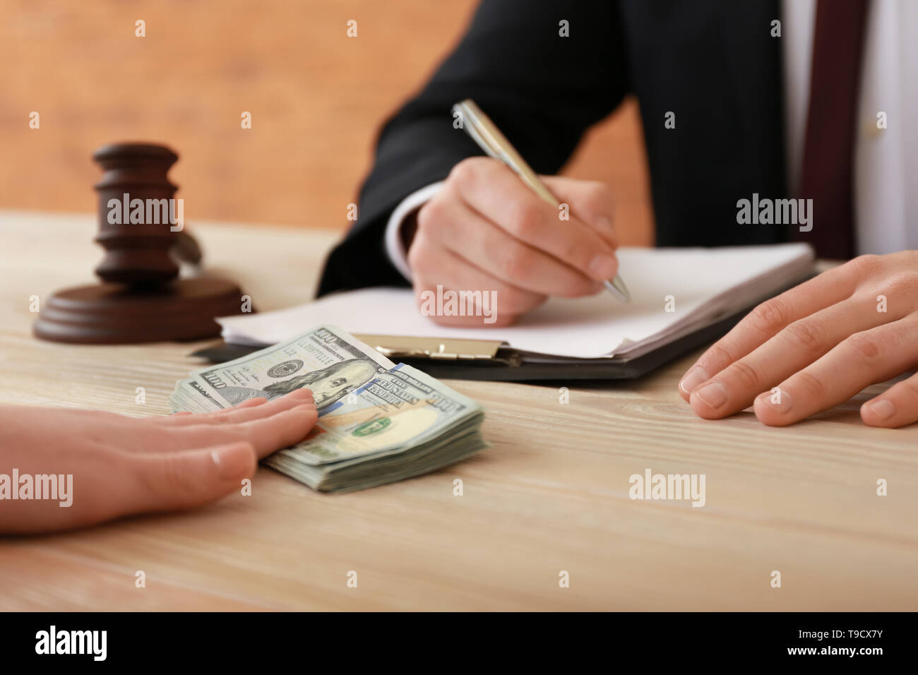 Woman giving bribe to judge at table, closeup. Corruption concept Stock ...