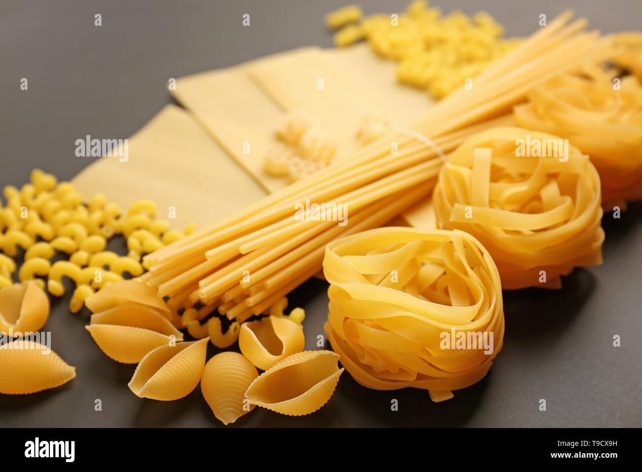 Different types of raw pasta on dark background Stock Photo - Alamy