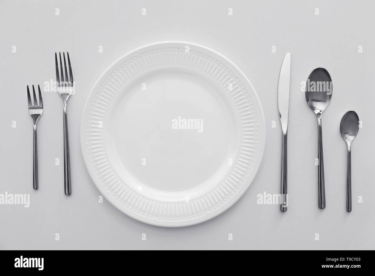 Plate and set of cutlery on white background, flat lay Stock Photo - Alamy
