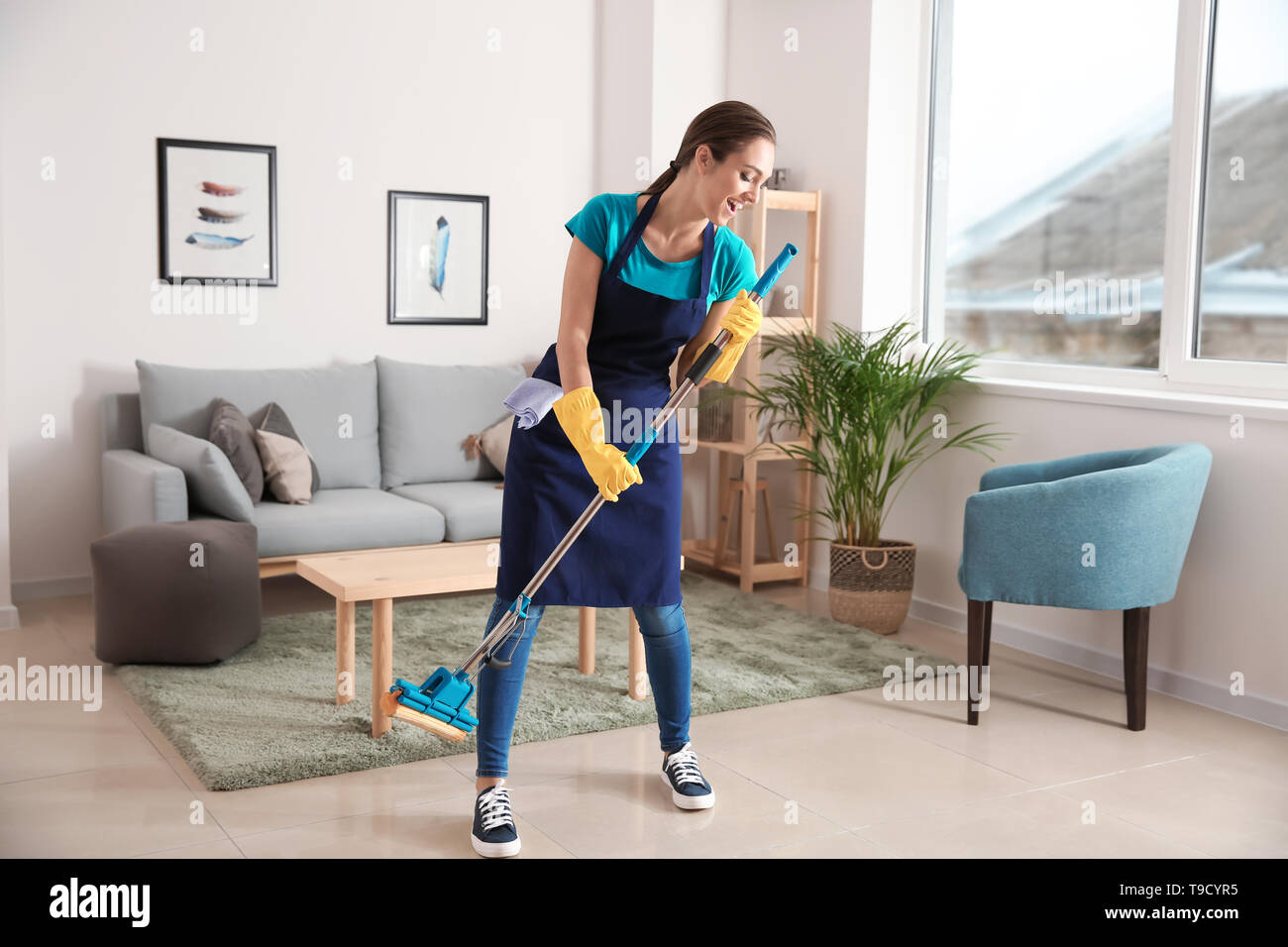 Female janitor having fun while cleaning flat Stock Photo - Alamy