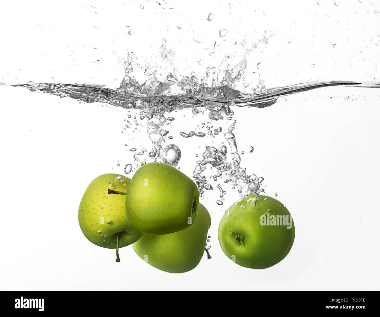 Falling of apples into water on white background Stock Photo - Alamy