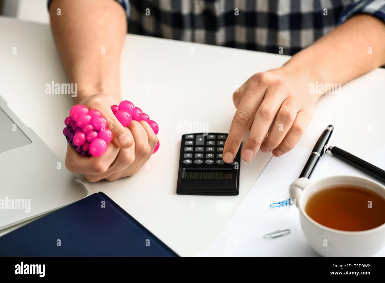 Woman squeezing stress ball at workplace Stock Photo - Alamy