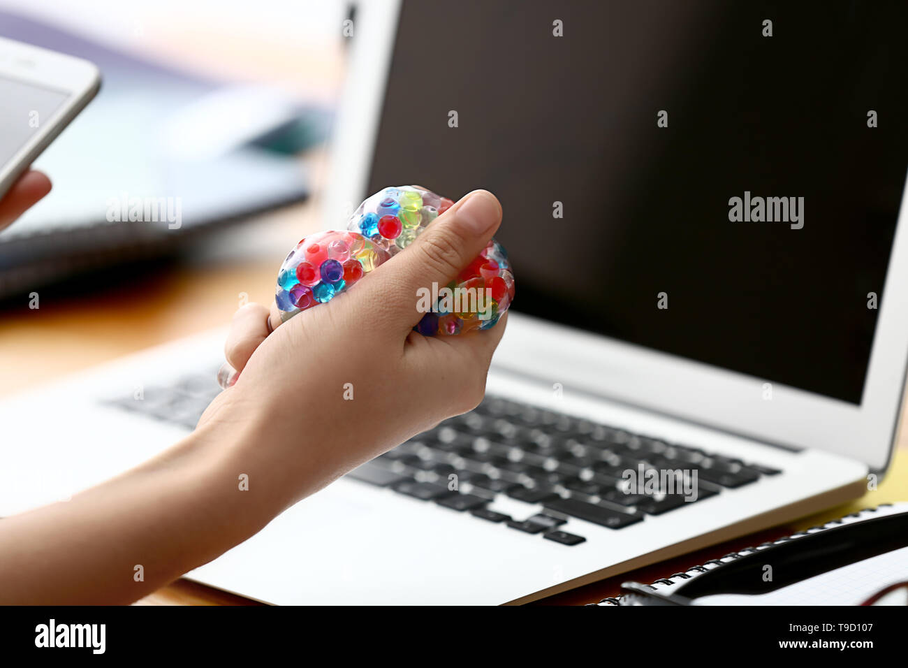 Woman squeezing stress ball at workplace Stock Photo - Alamy