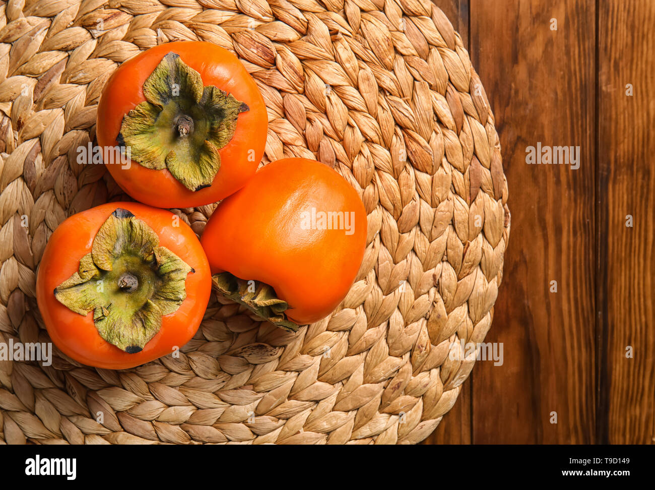 Tasty ripe persimmons on wicker mat Stock Photo - Alamy