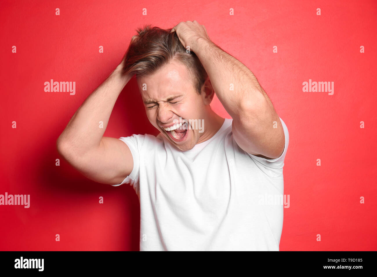 Portrait of screaming young man on color background Stock Photo - Alamy