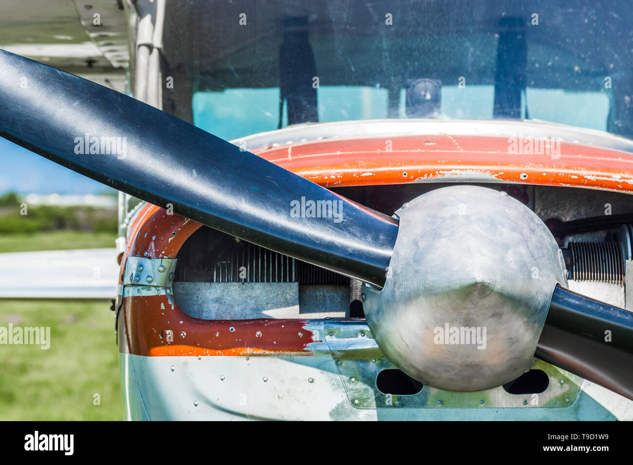 Small light utility aircraft, worn red and white paint, front view of ...