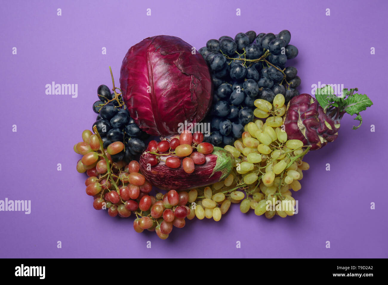 Different types of grapes with vegetables on color background Stock ...