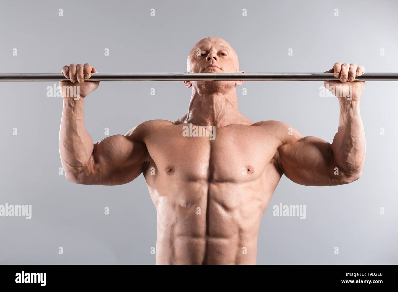 Muscular bodybuilder training on grey background Stock Photo - Alamy