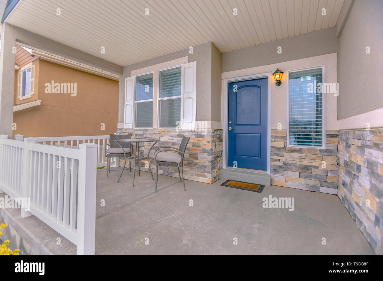 Home exterior with a blue front door and reflective glass windows Stock ...