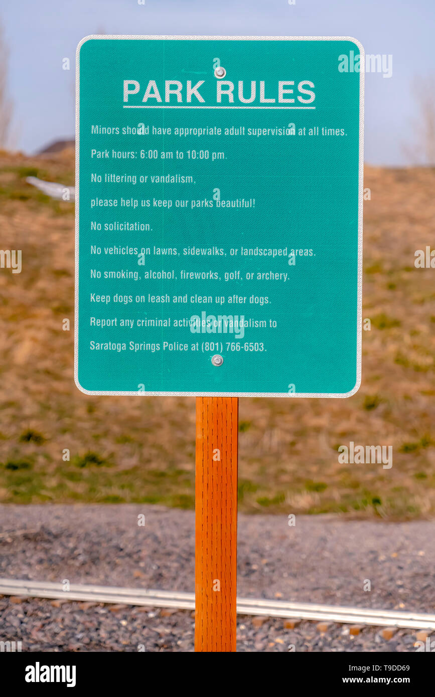 Close up of a Park Rules signage against a rocky and grassy landscape ...