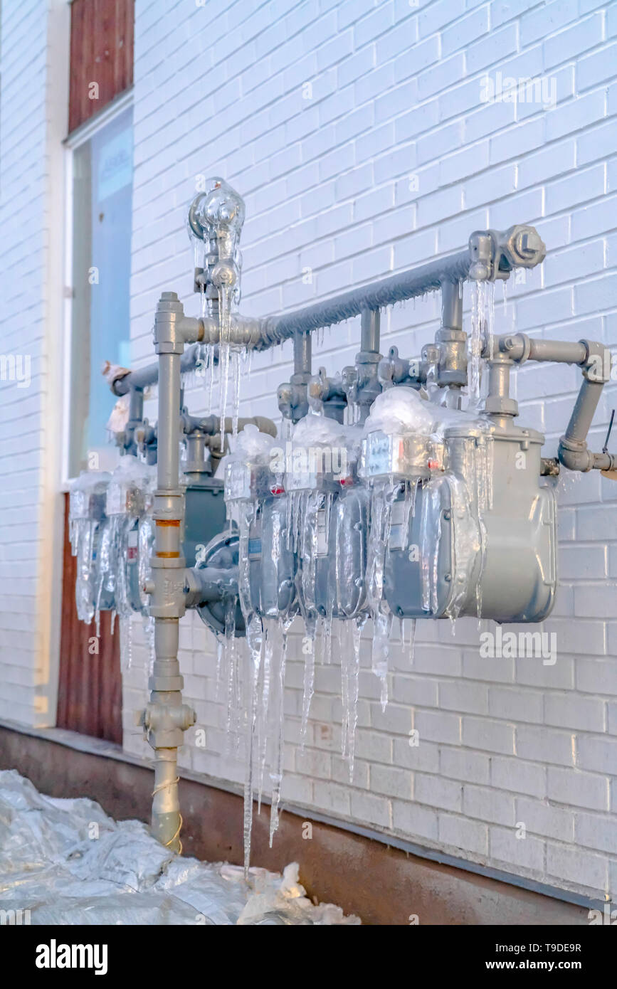 Water meters and pipes outside a building in Eagle Mountain with brick ...