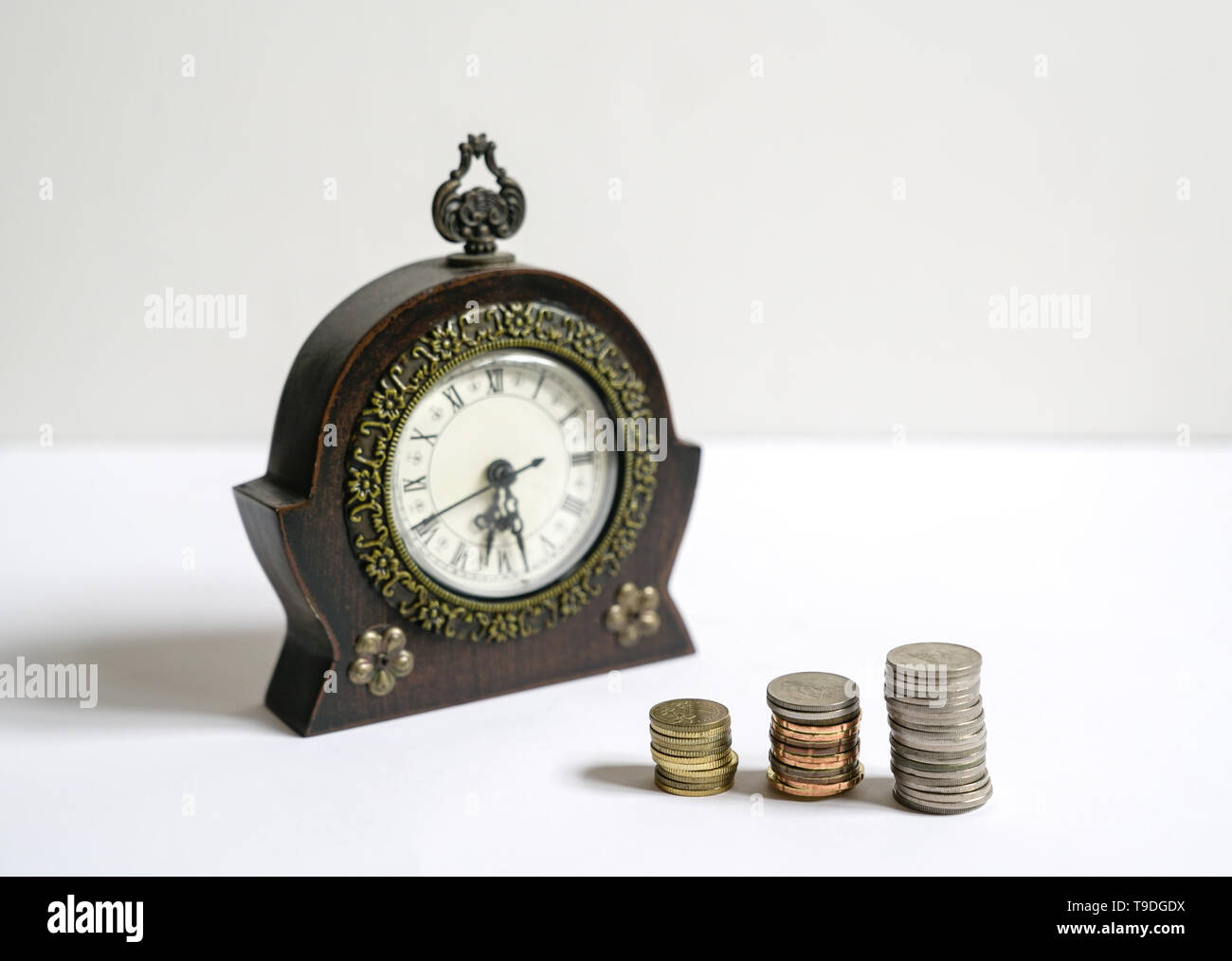 Clock and stacked coins. Time is money or savings concept Stock Photo ...