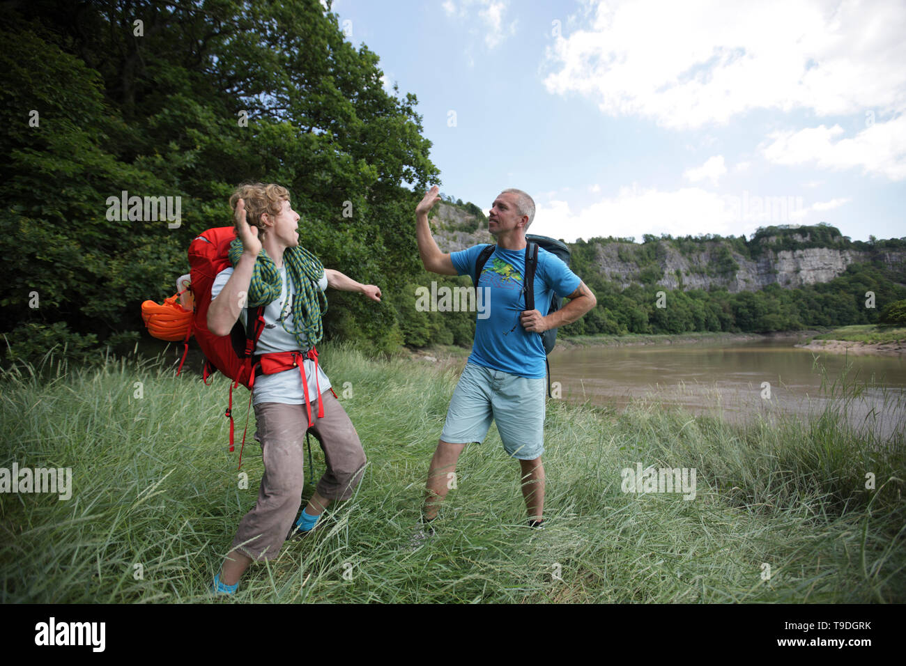 Two male climbers high five to celebrate their successful climb at ...