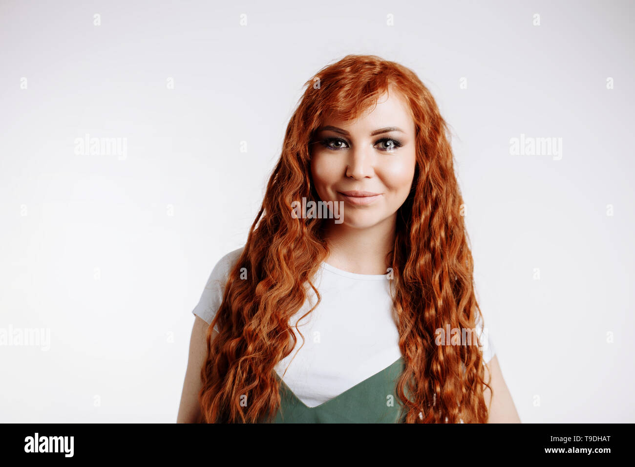 Pretty smiling joyfully female with red hair, dressed casually, being ...