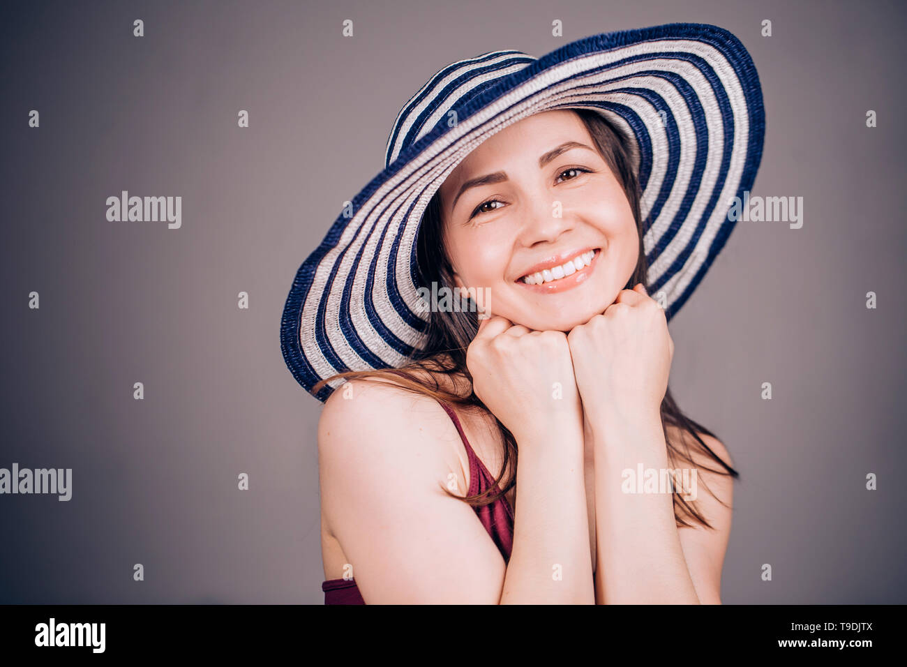 Cheerful smiling woman wearing striped hat and the hand holds on the ...