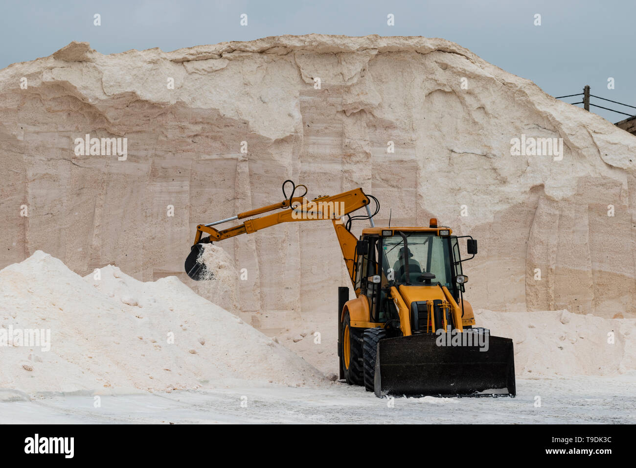 excavator in a salty mountain or salt production or making a pile of ...