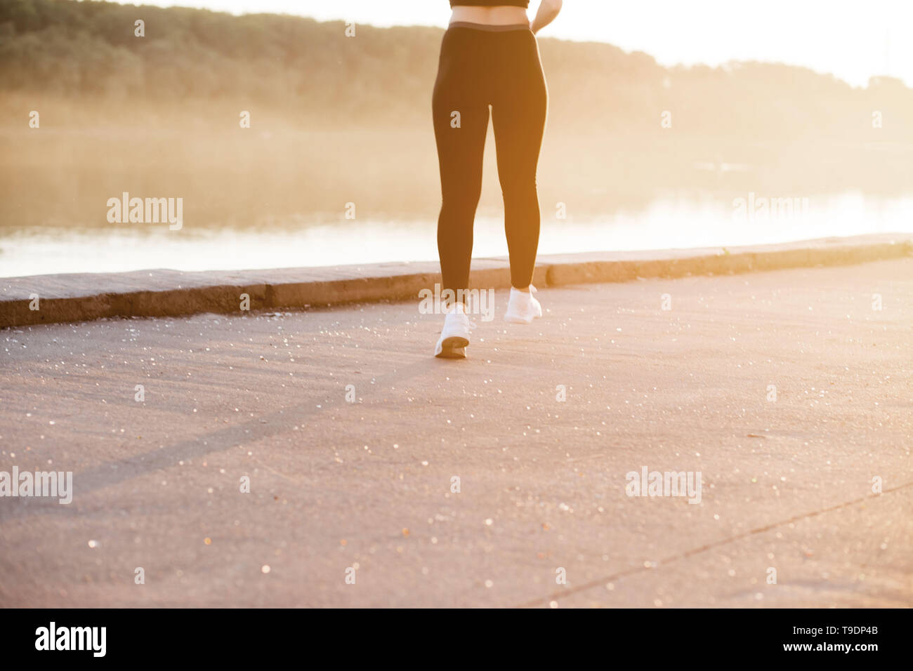 Girl runs around at sunset. Cropped photos of feet in white sneakers ...