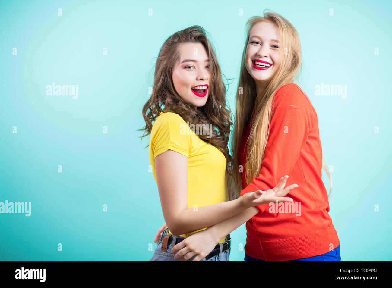 Happy positive moments of two stylish girls on blue background Stock ...