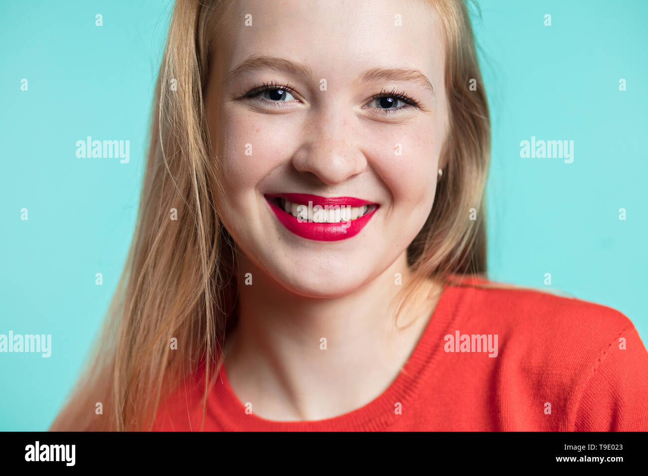 Cheerful young woman on blue background. Positive human emotion, facial ...