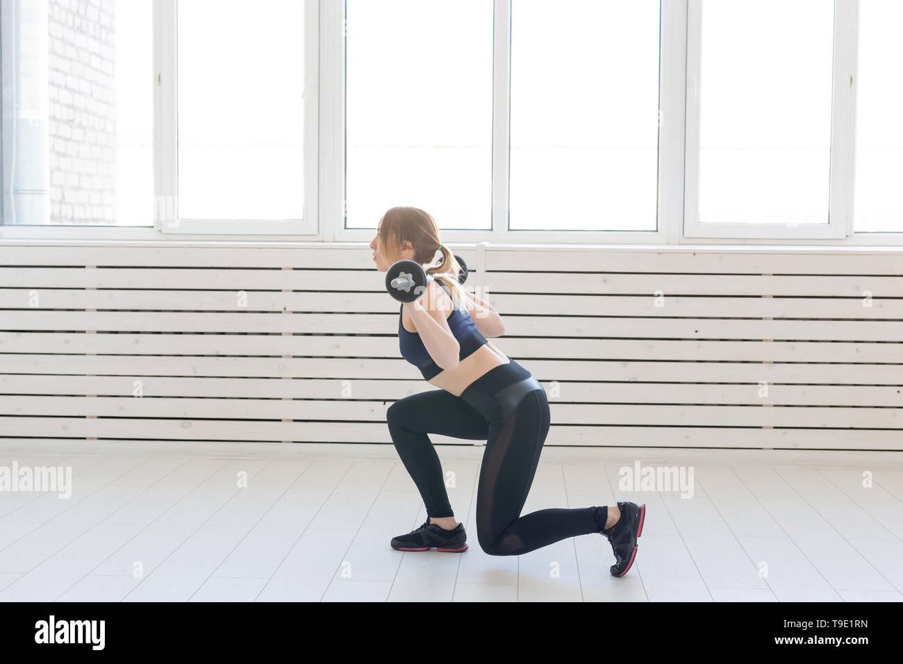Fitness, sport and people concept - smiling sporty woman with barbell ...