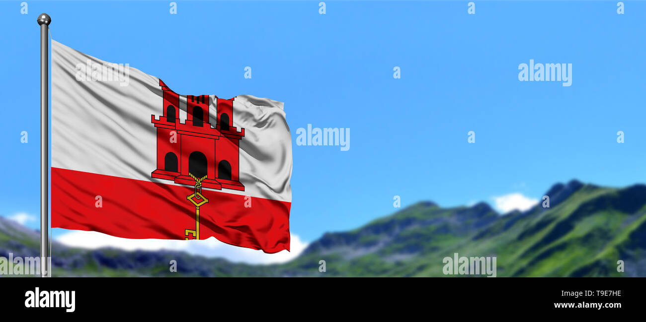 Gibraltar flag waving in the blue sky with green fields at mountain ...