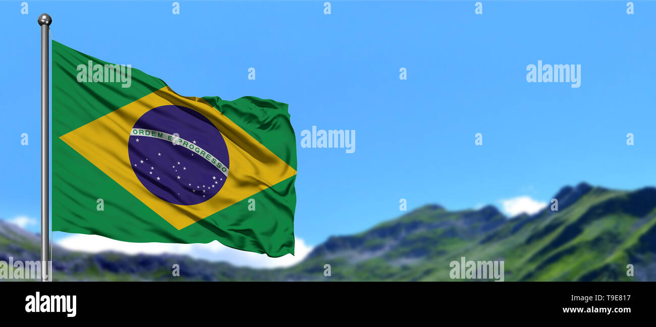 Brazil flag waving in the blue sky with green fields at mountain peak ...