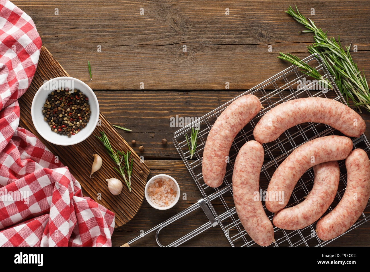 Raw sausages on grill and ingredients for cooking. Barbecue preparation ...