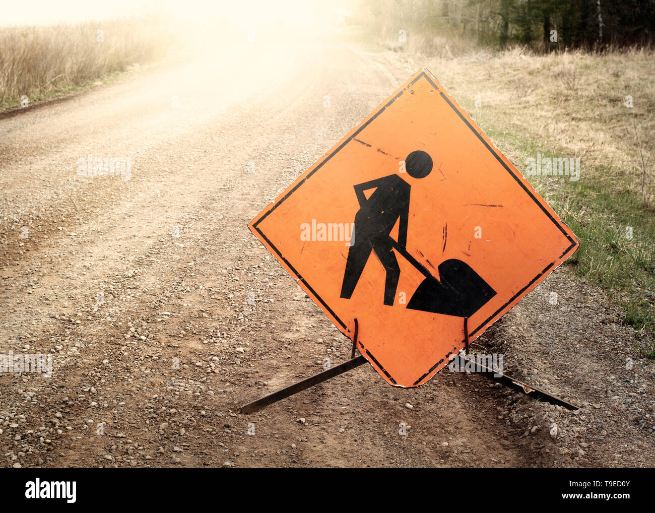 People working caution sign on rural dirt road with sun flare Stock ...