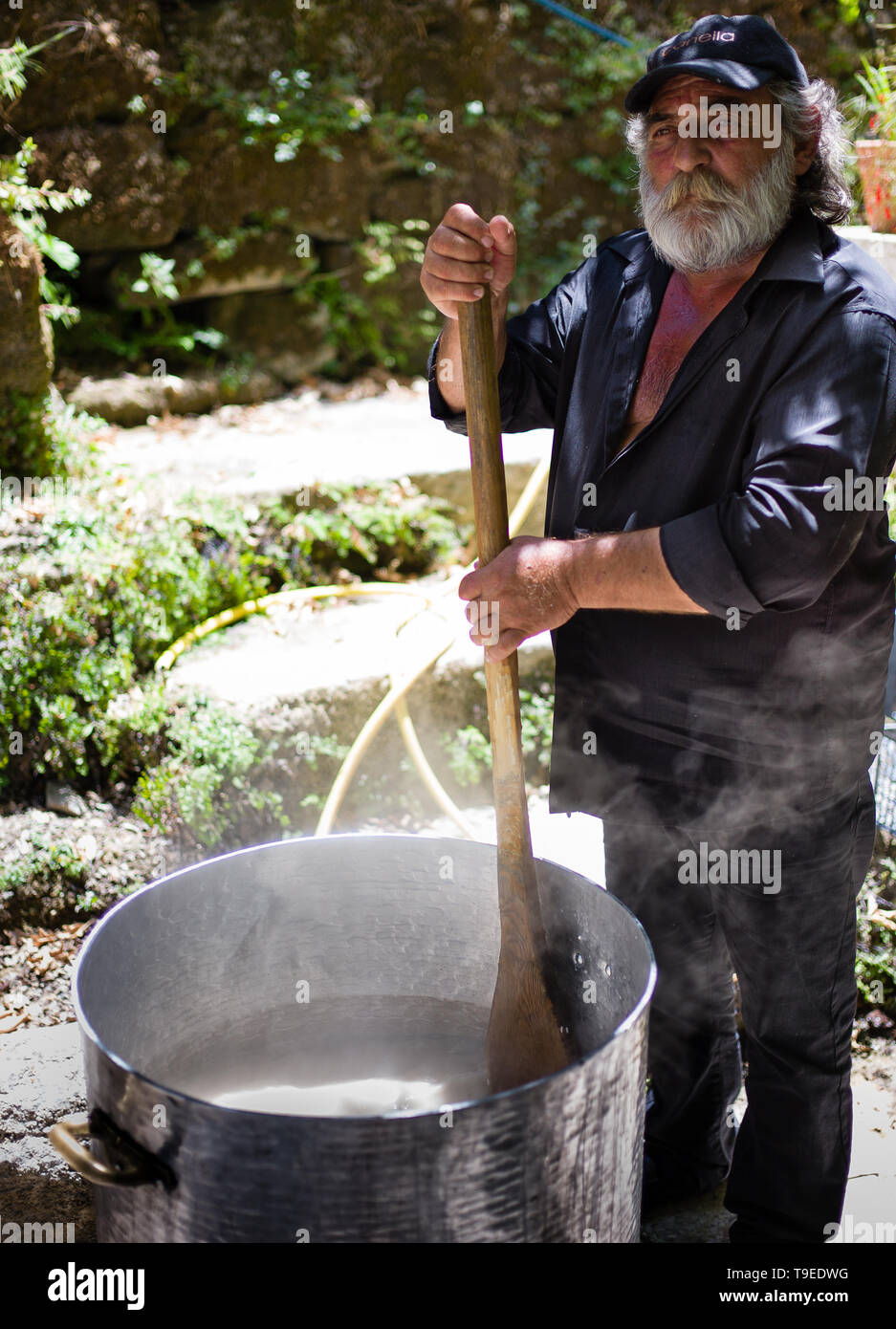 Traditional Cretan man with white beard making wedding rice for a ...
