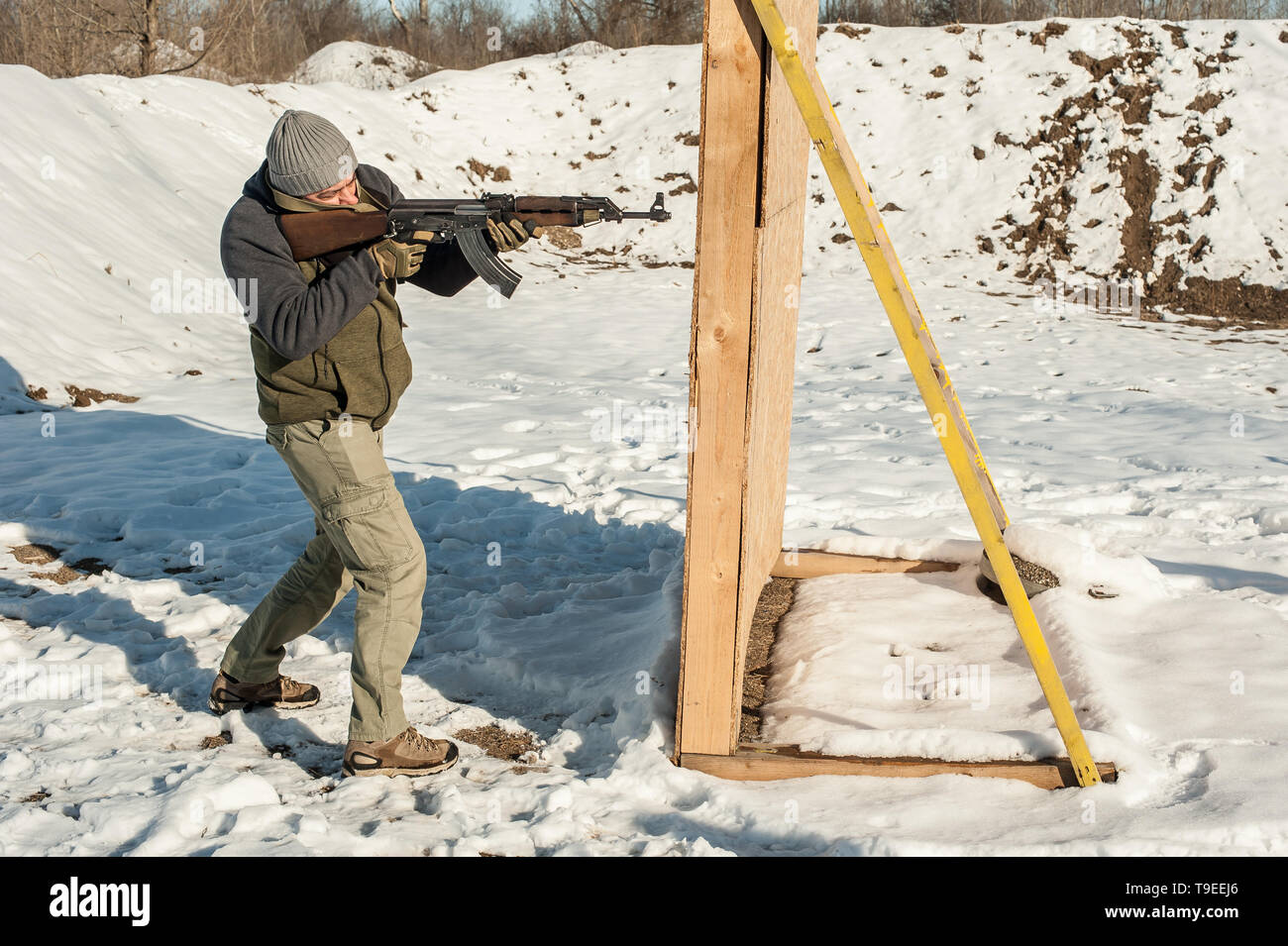 Instructor demonstrate body position of combat rifle shooting at winter ...