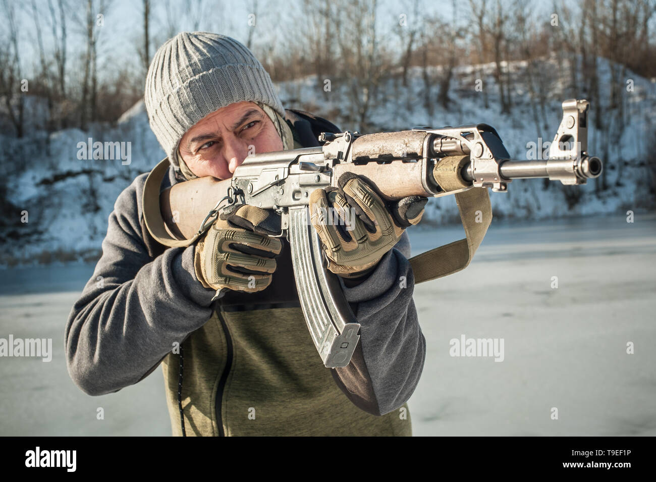 Instructor demonstrate body position of combat rifle shooting at winter ...