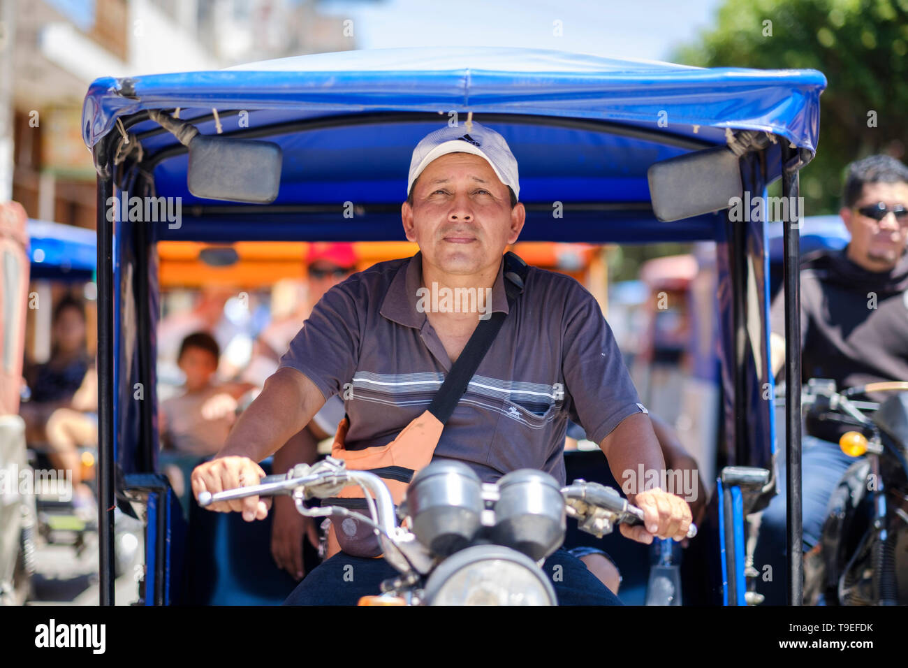Portrait of mototaxi driver at work on the busy streets of Yurimaguas ...