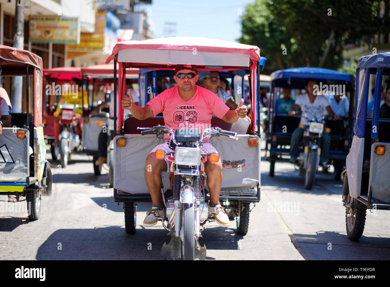 Portrait of mototaxi driver at work on the busy streets of Yurimaguas ...