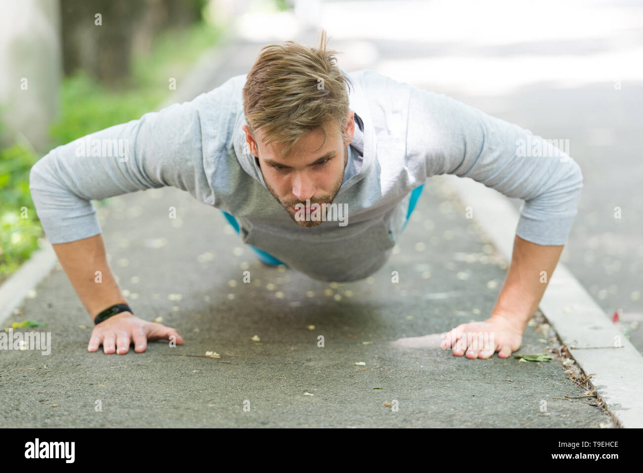 Strength and motivation. Man in sportswear doing push ups outdoor. Guy ...