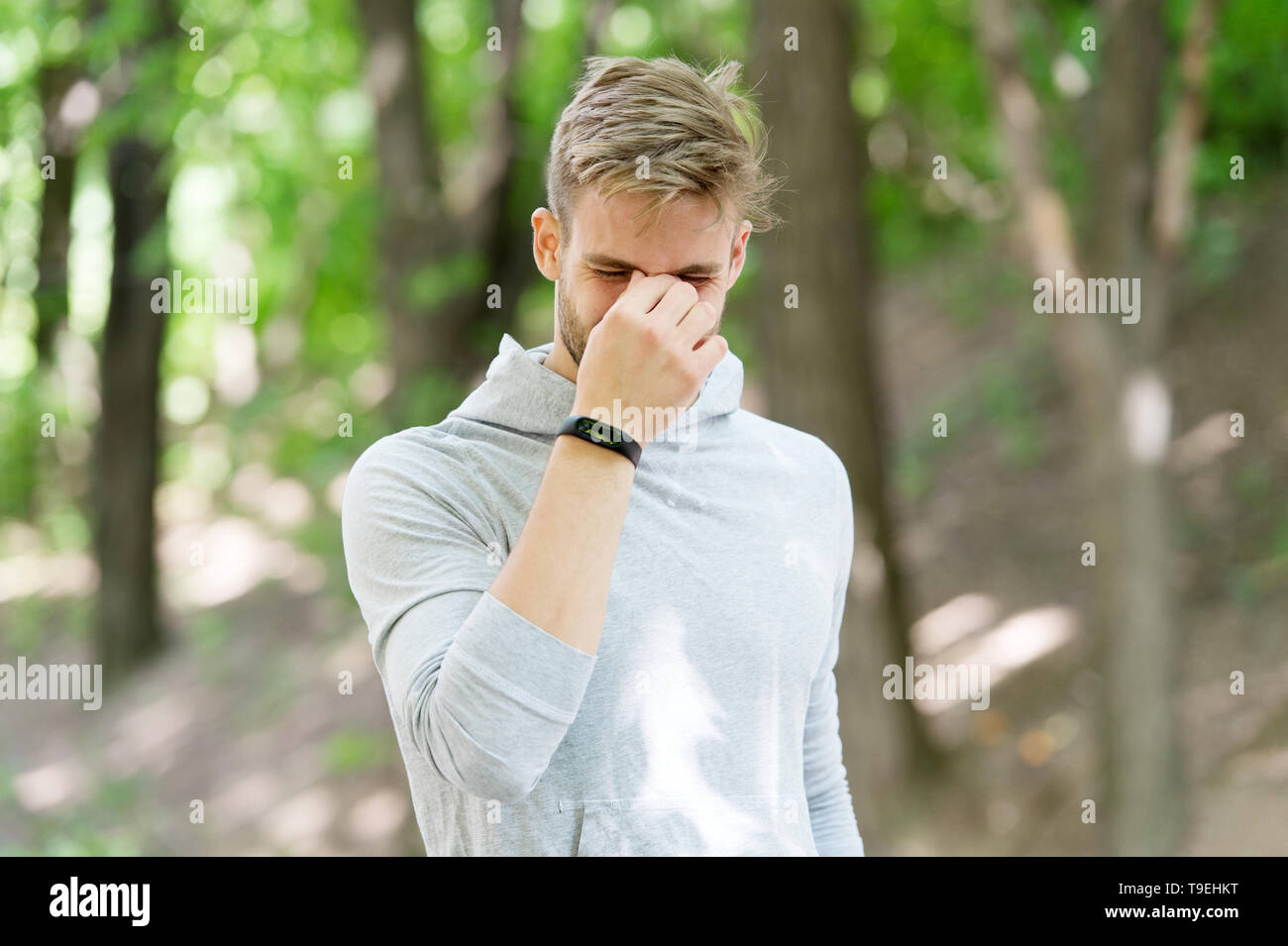 Pain after workout. Man jogger stop running in park because of headache ...