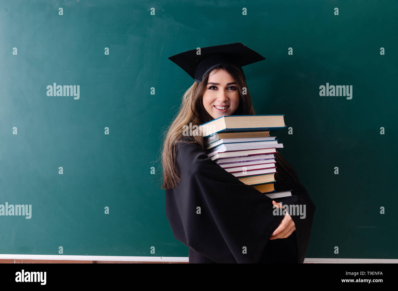Female graduate student in front of green board Stock Photo - Alamy