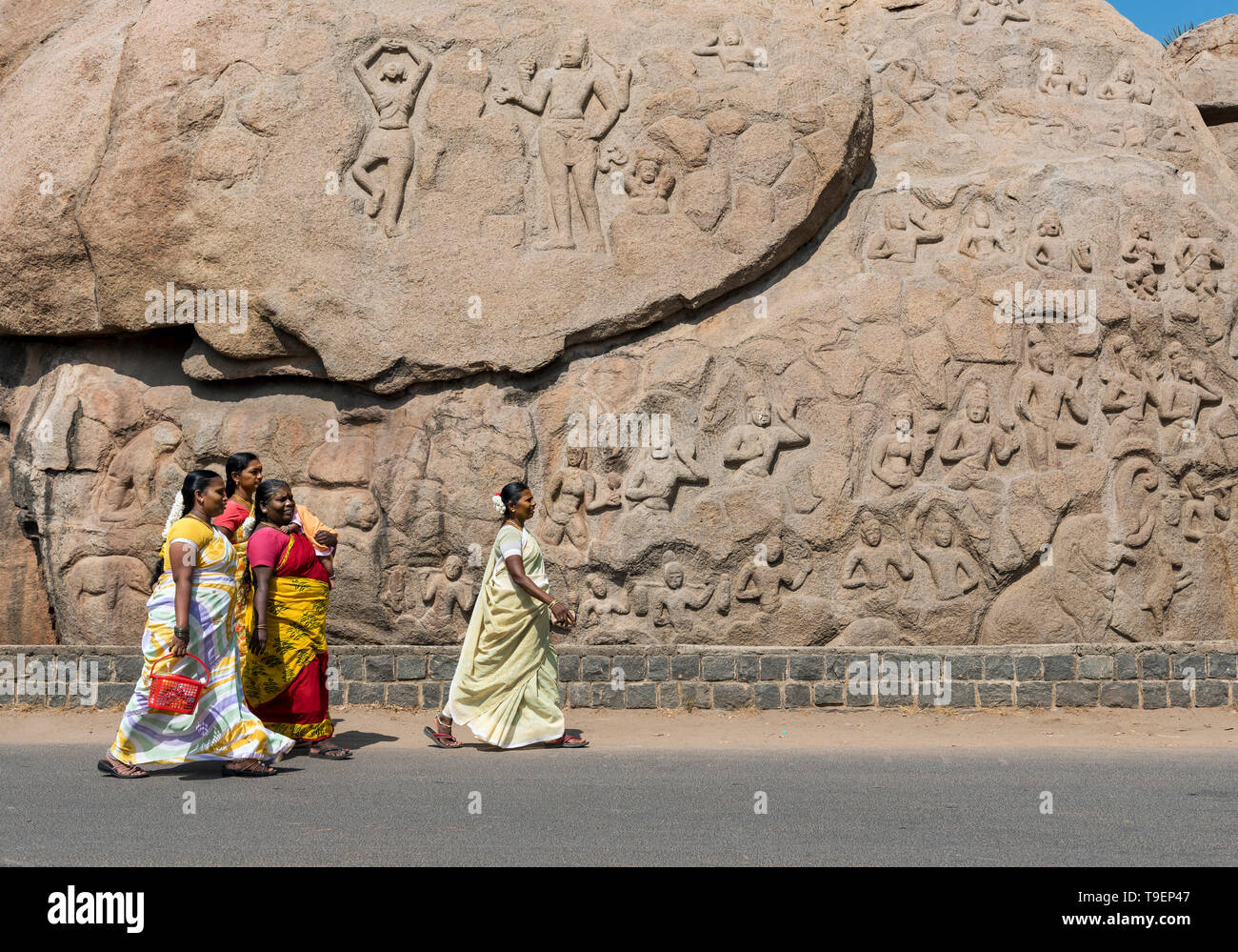 Group of women in traditional sari dress pass Unfinished Relief Carving ...