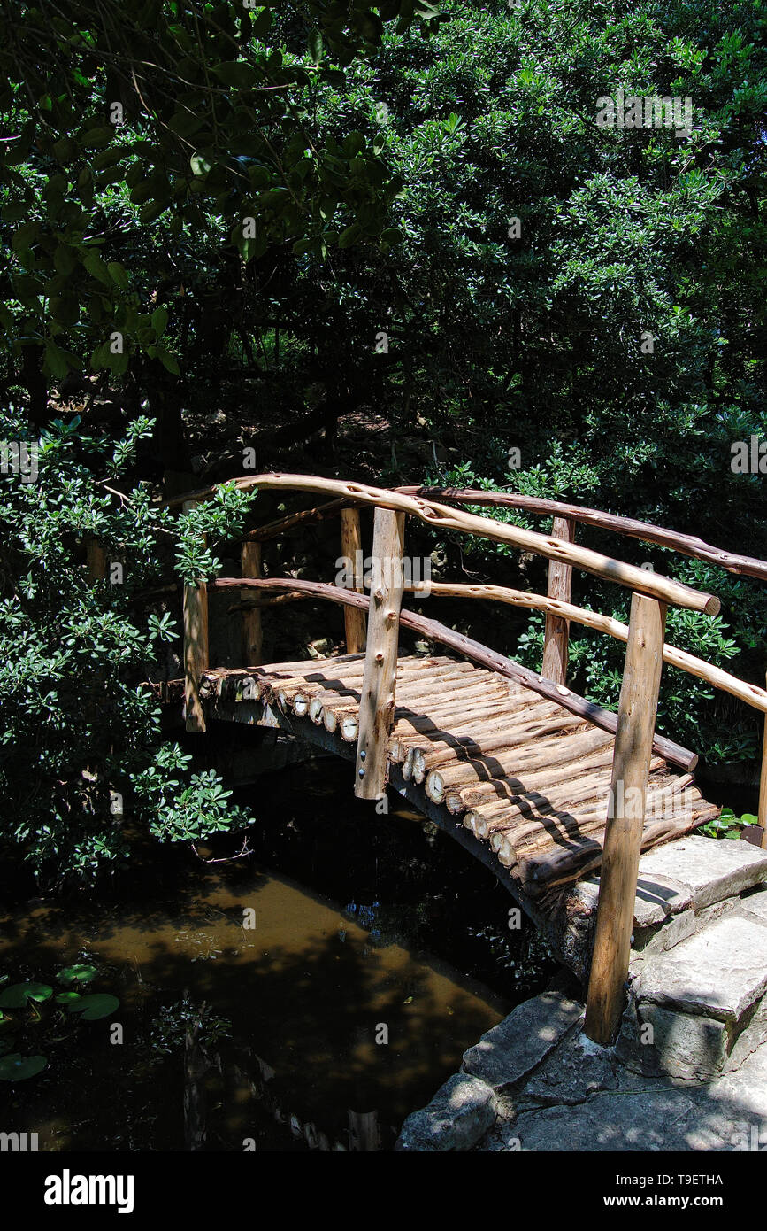 Log bridge in a Japanese water garden Stock Photo - Alamy