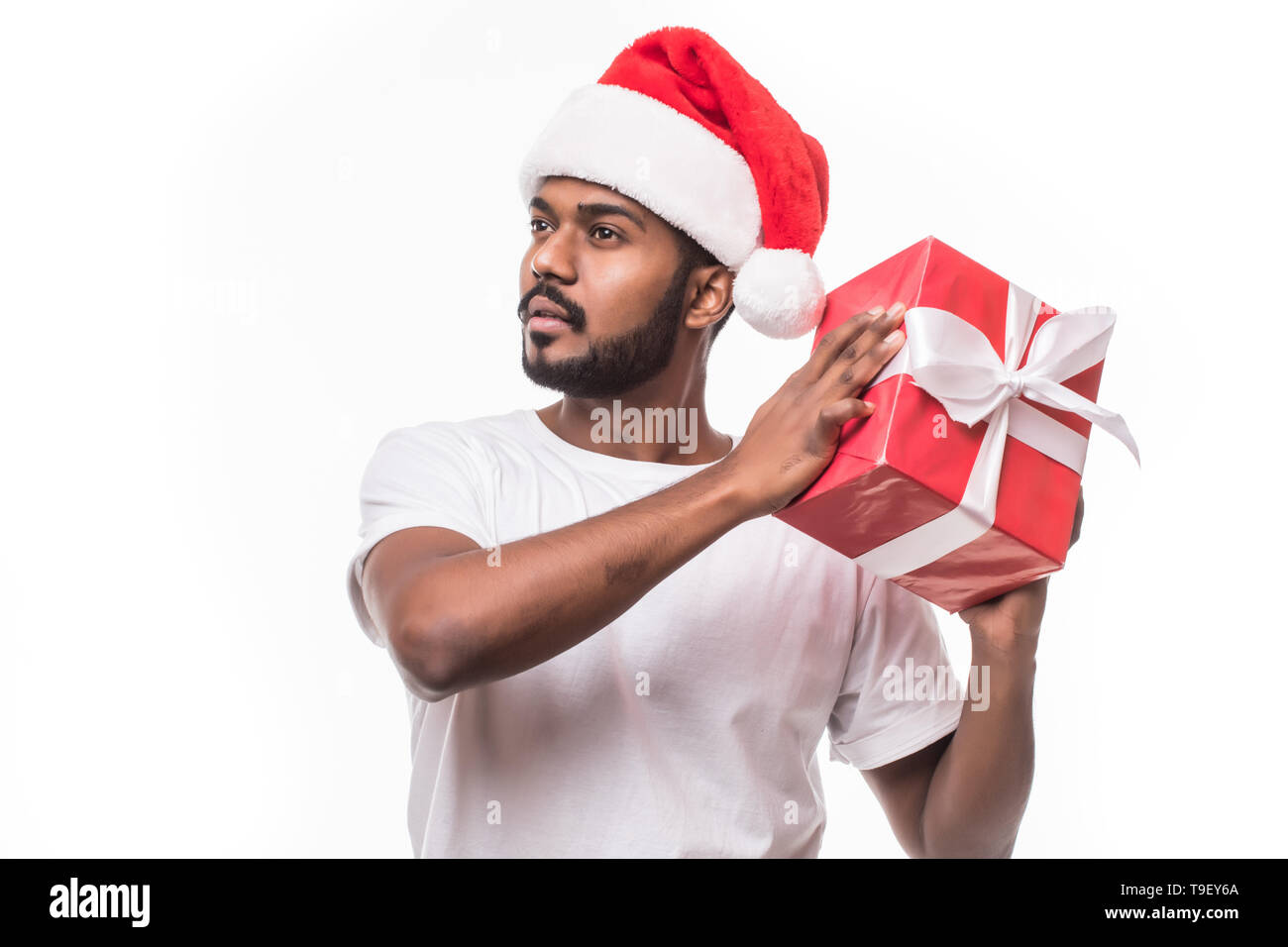 Happy indian man wearing santa hat and holding gift box isolated on ...