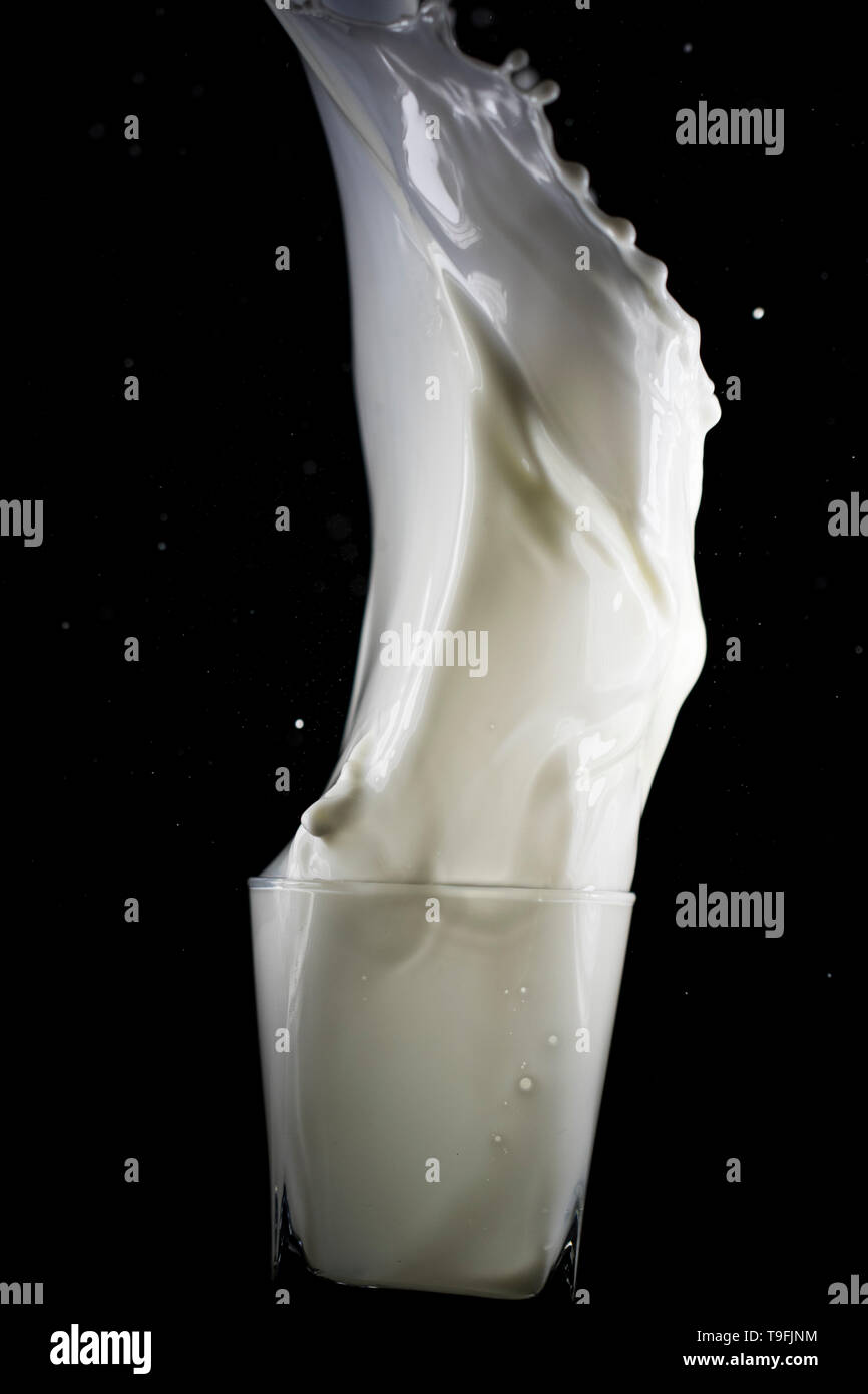Dynamic wave of liquid splashing out of a glass. Refreshing glass of ...