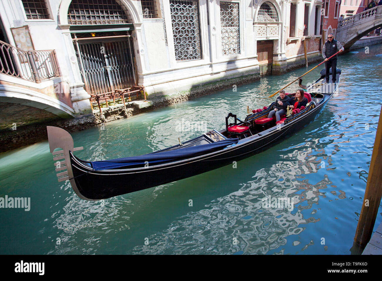 Gondolier rowing tourists in gondola, Venice, Italy Stock Photo - Alamy